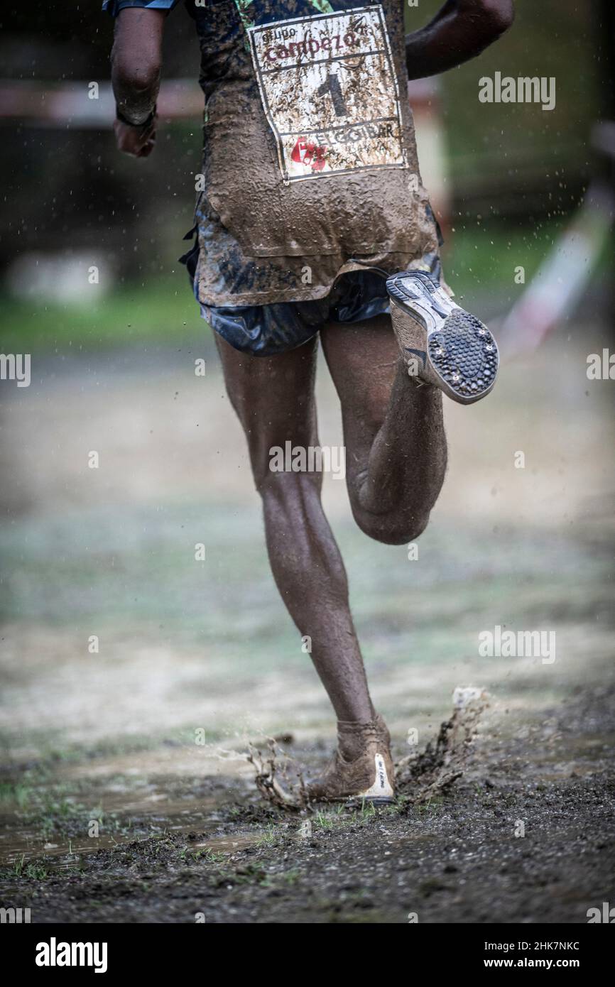 Athlete's legs running in a Cross Country between water and mud, pure ...