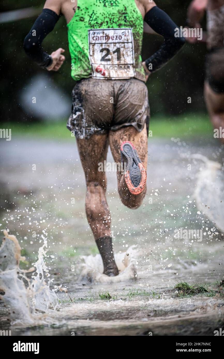 Athlete's legs running in a Cross Country between water and mud, pure ...