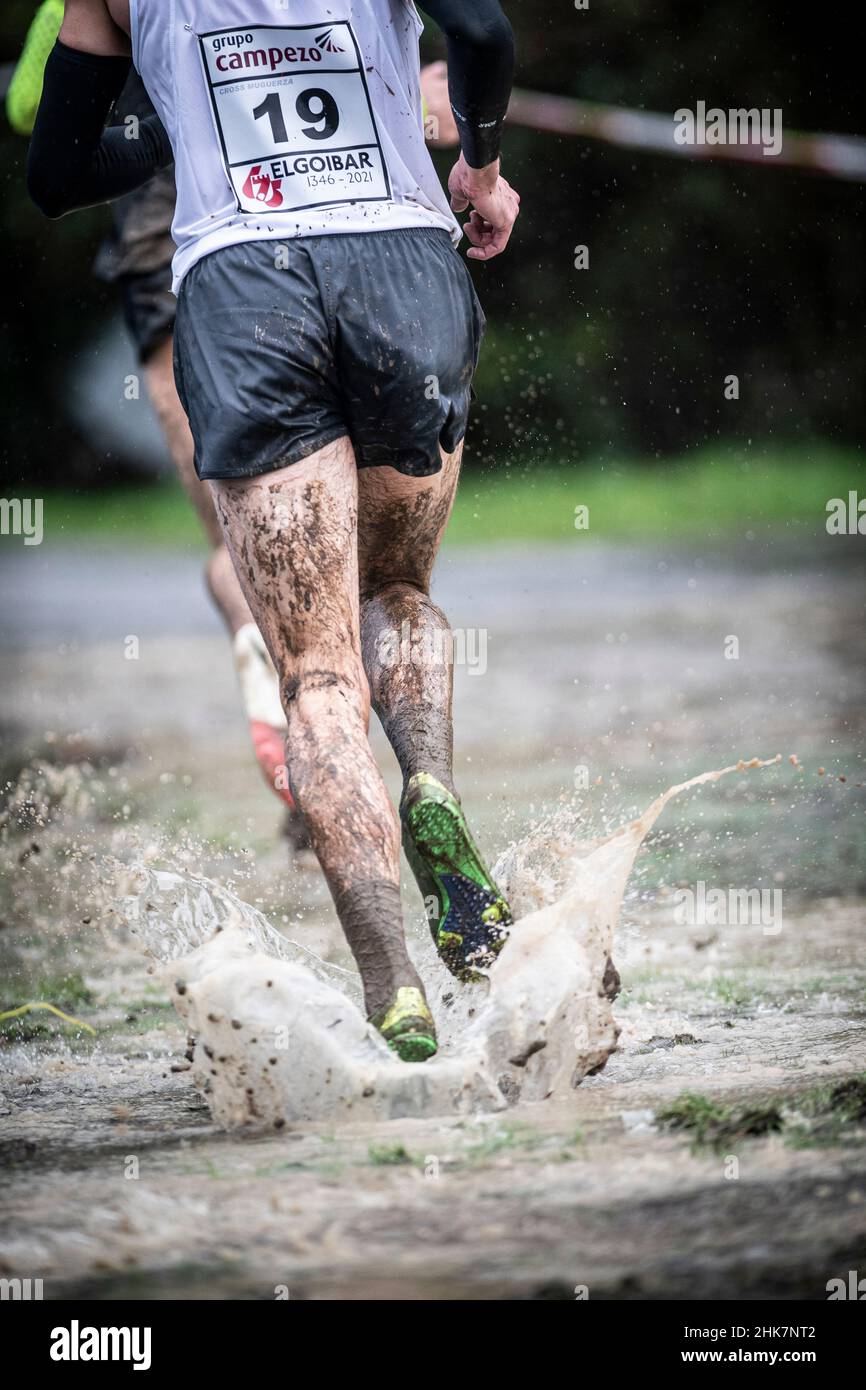 Athlete's legs running in a Cross Country between water and mud, pure ...