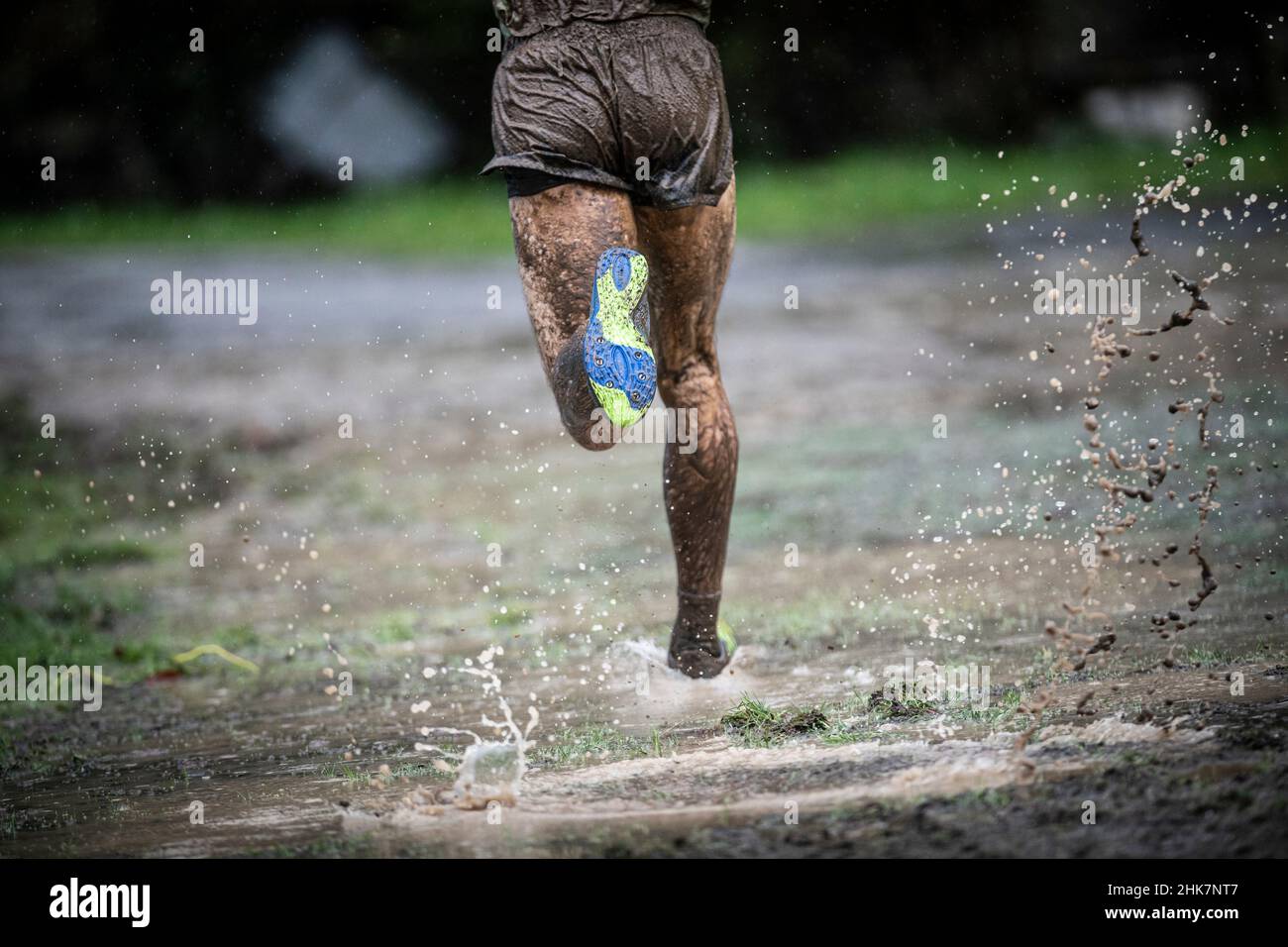 Athlete's legs running in a Cross Country between water and mud, pure ...