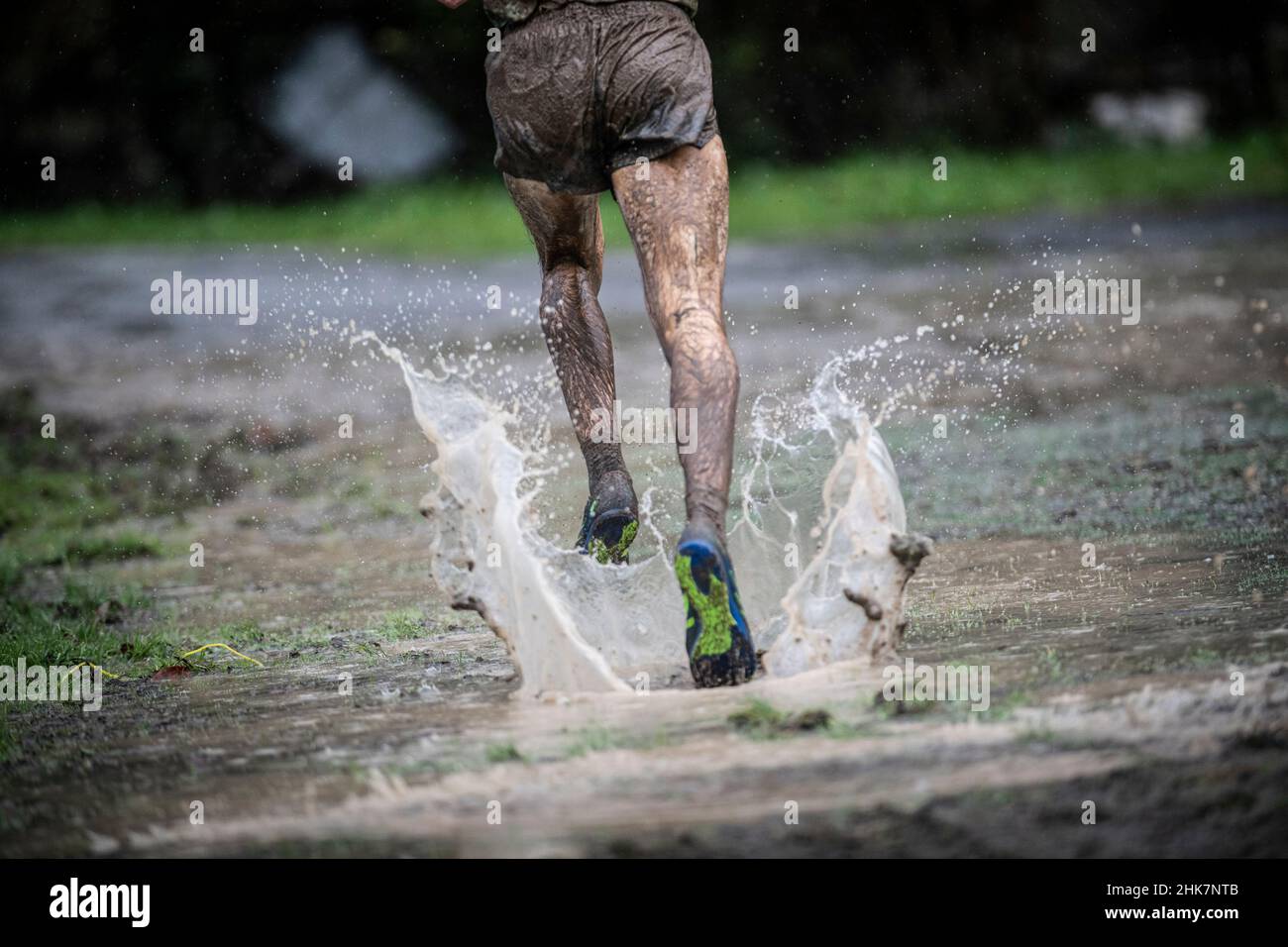 Athlete's legs running in a Cross Country between water and mud, pure ...
