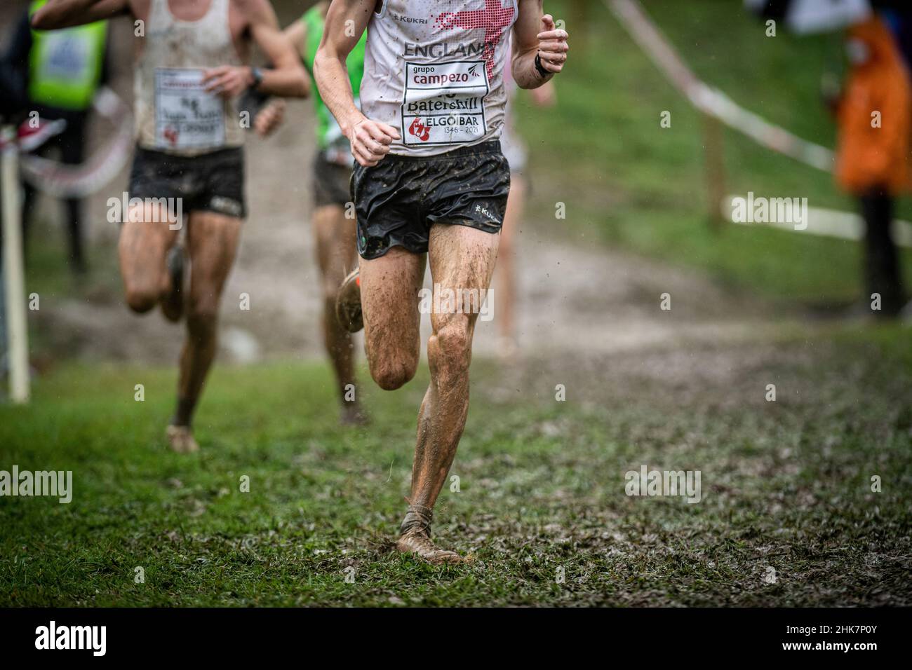 Athlete's legs running in a Cross Country between water and mud, pure ...