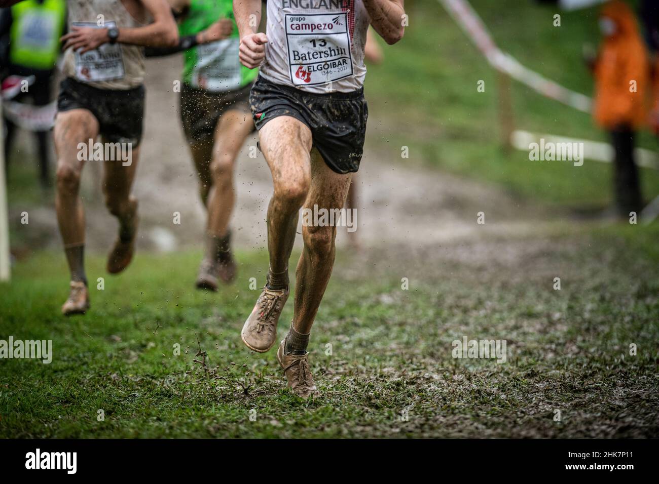 Athlete's legs running in a Cross Country between water and mud, pure ...
