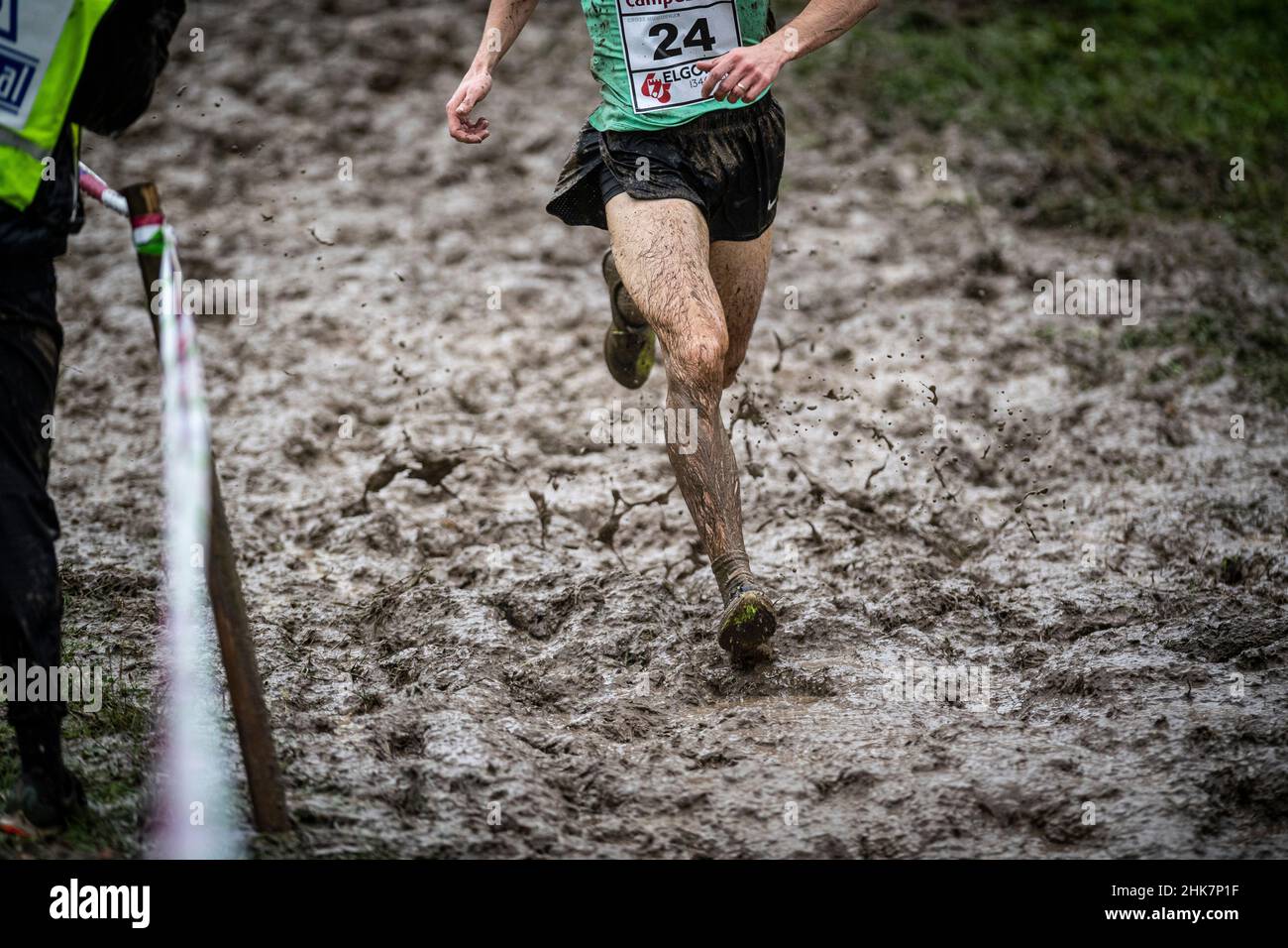 Athlete's legs running in a Cross Country between water and mud, pure ...