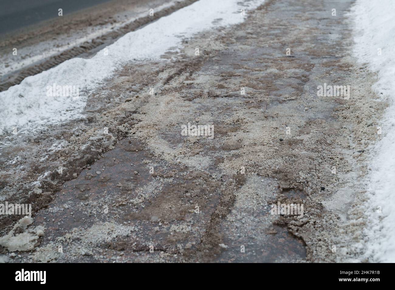 Closeup view of technical salt grains on icy sidewalk surface in ...