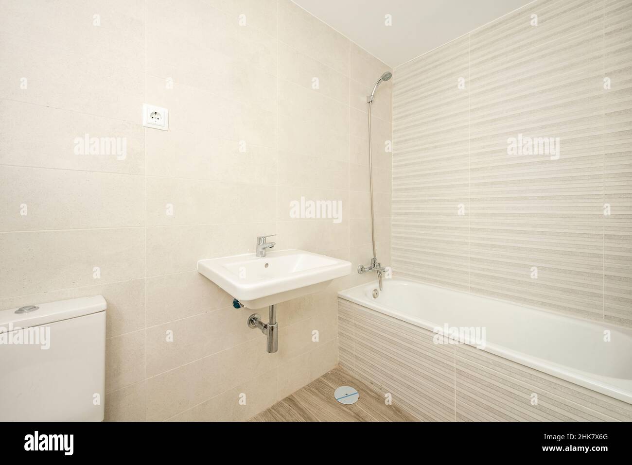 Bathroom with stoic cabinetry and light cream tile and white porcelain ...