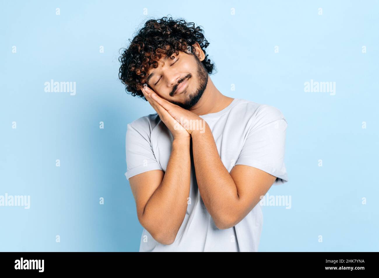 Positive indian or arabian dreamy smiling guy, hold his hands near ...