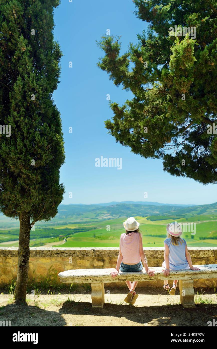 Two sisters admiring the view of green fields and farmlands with small ...