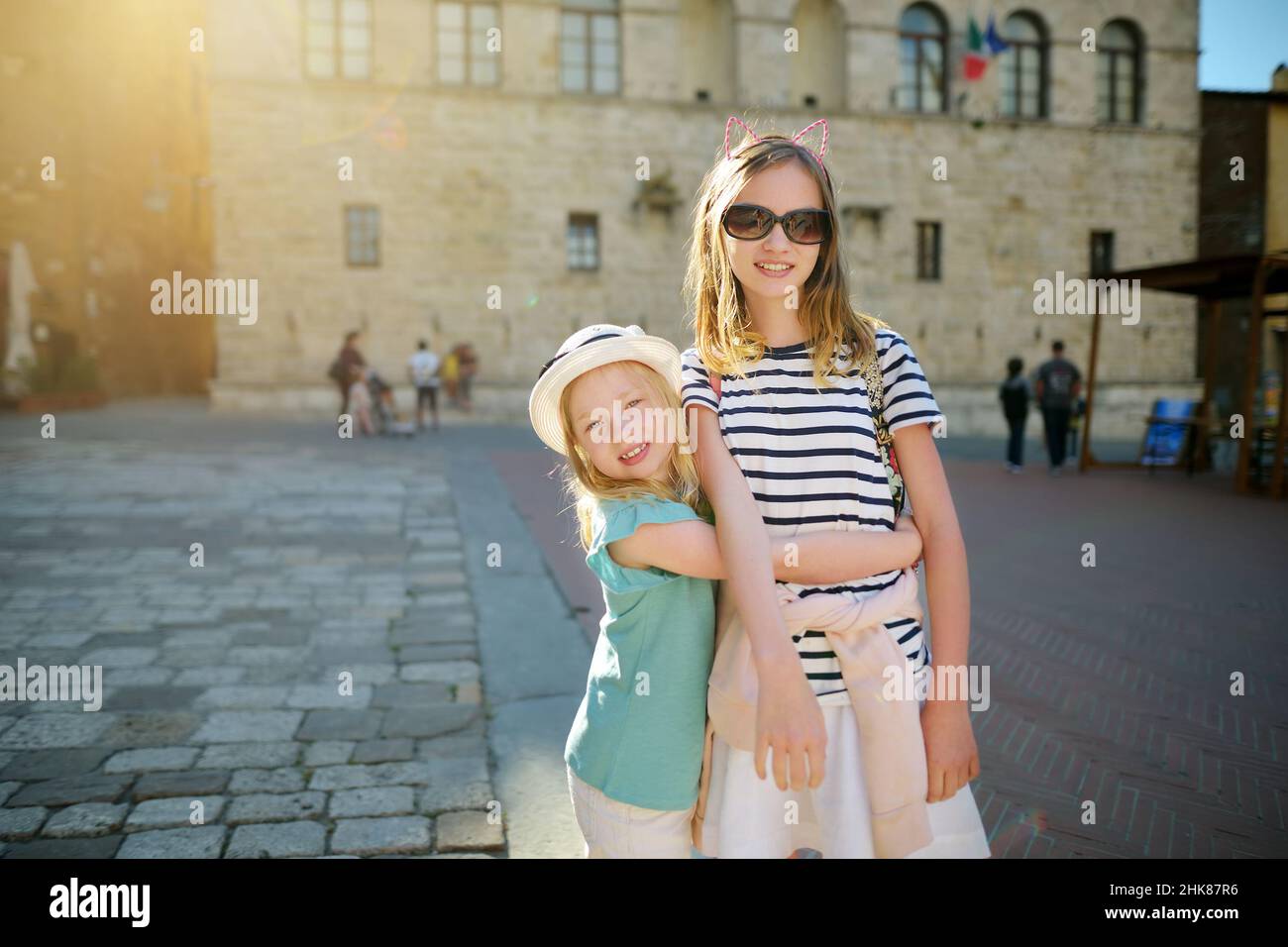 Two sisters exploring old narrow streets of famous Montepulciano town ...