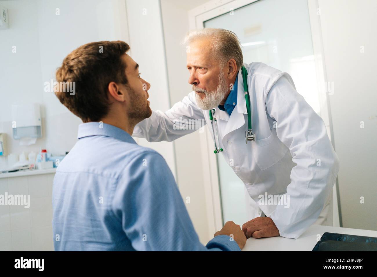 Close-up of mature adult male ophthalmologist examining eyes of male ...