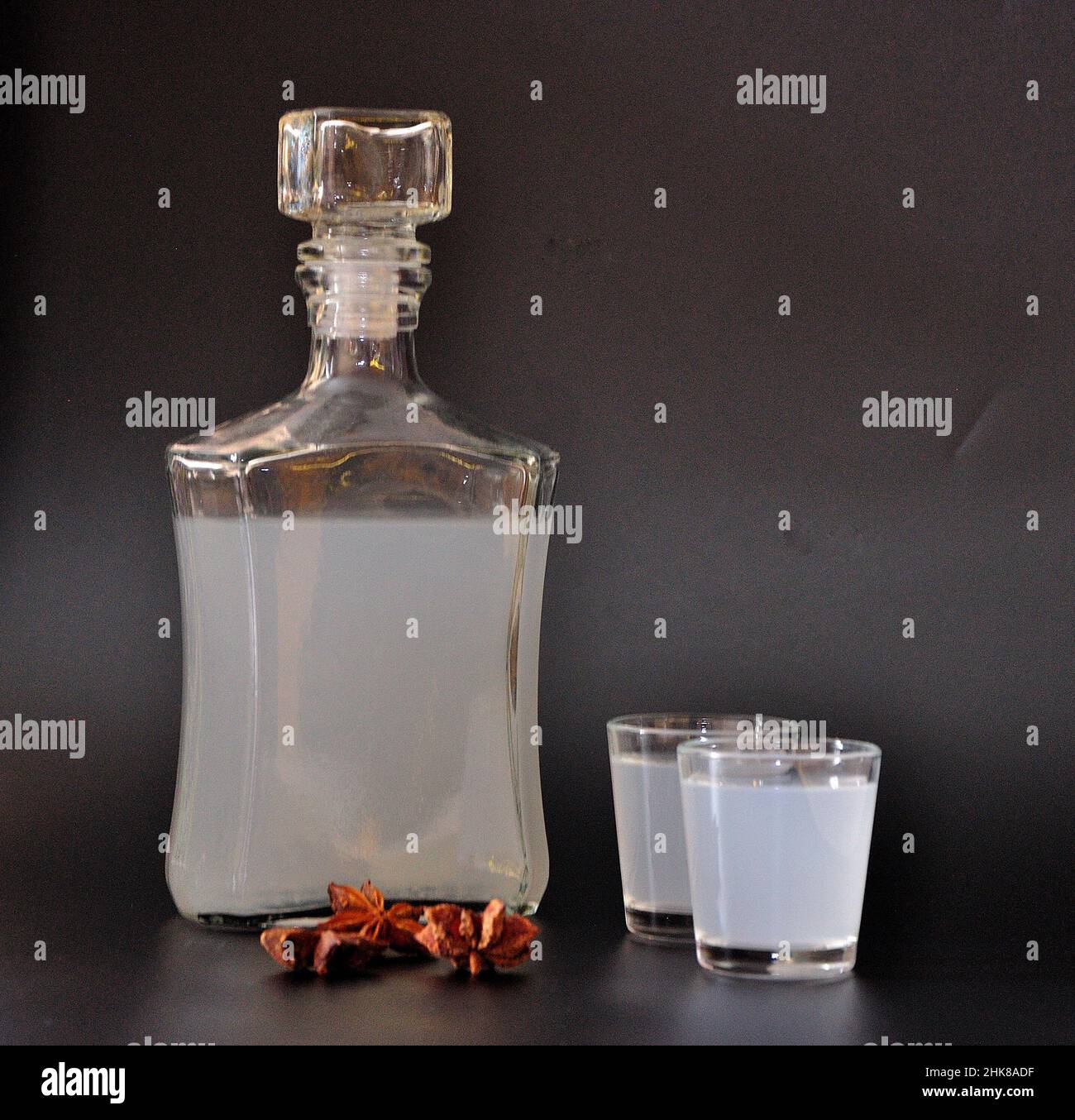 Anise liqueur, strong homemade alcohol, a bottle and two glasses with a ...