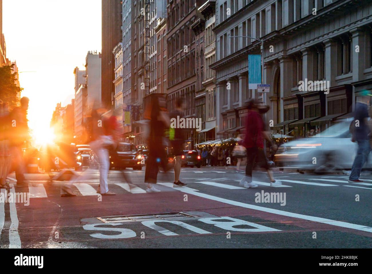 Diverse crowd of people walking across a busy intersection on 23rd ...
