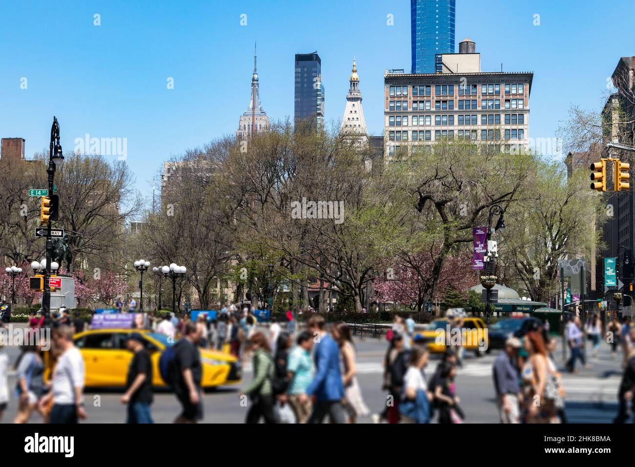Diverse crowd of people walking through a busy intersection on 14th ...