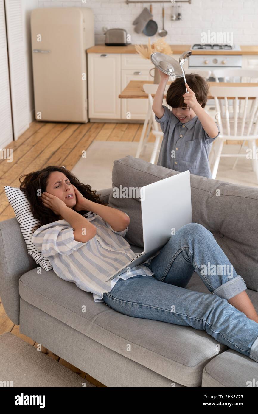 Stressed mother look desperate on loud child suffer from headache. Mom ...
