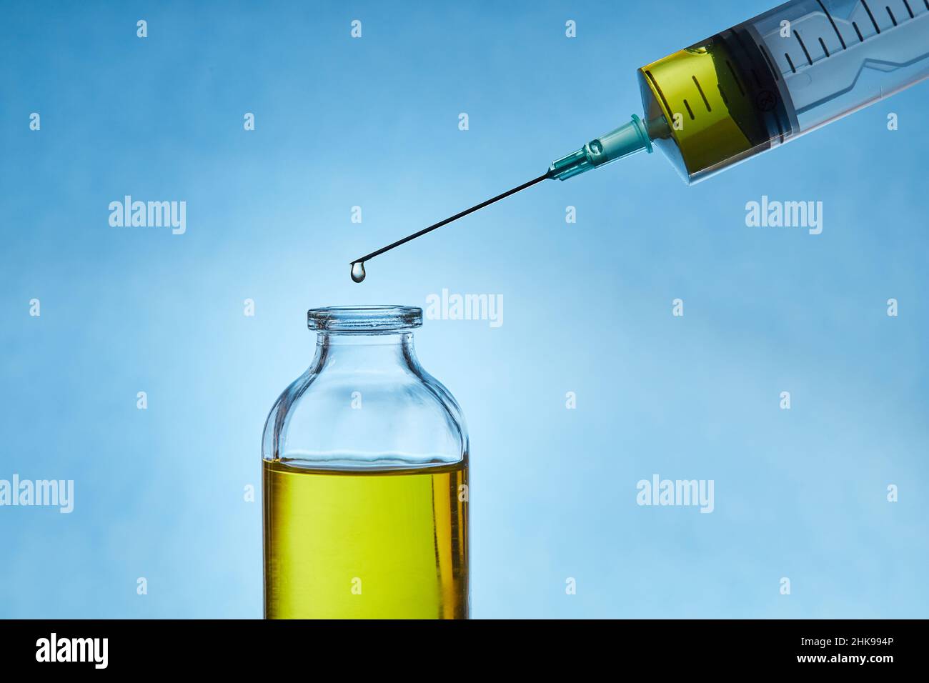 A drop of liquid drips from the needle of a medical syringe into the ...