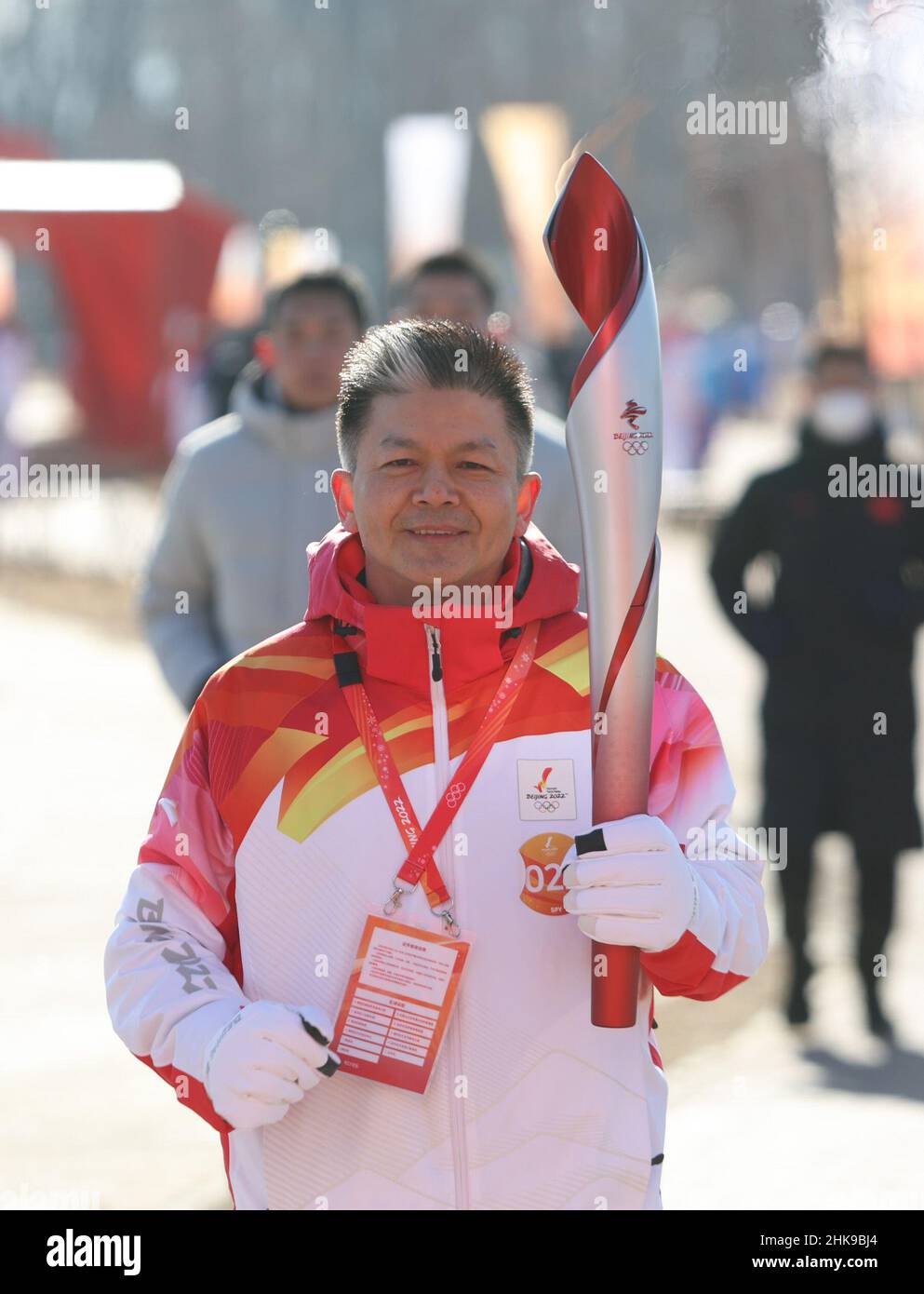 Beijing, China. 3rd Feb, 2022. Torch bearer Zeng Maojun runs with the ...