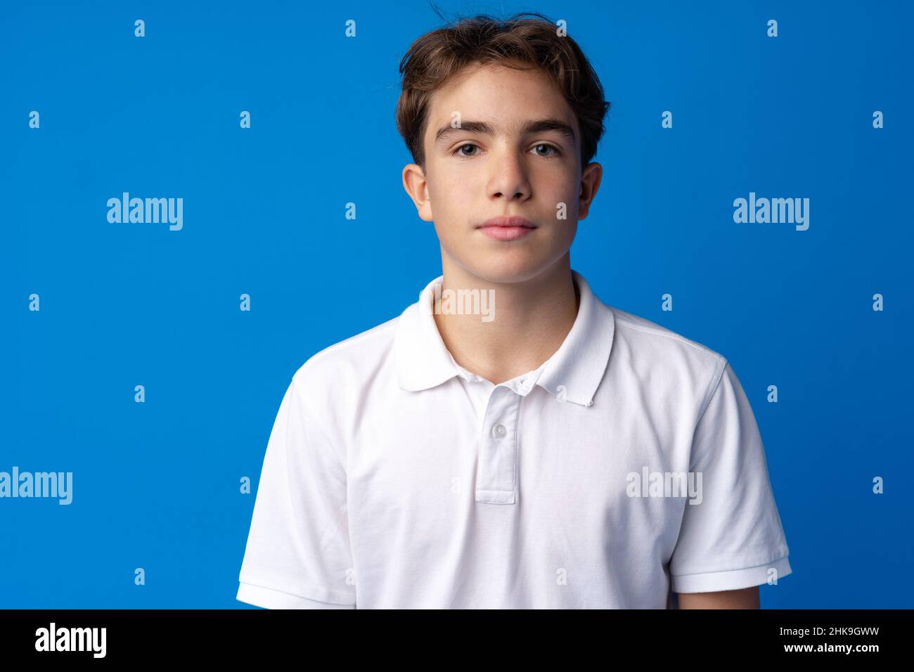 Portrait of a smiling teen boy against blue background Stock Photo - Alamy