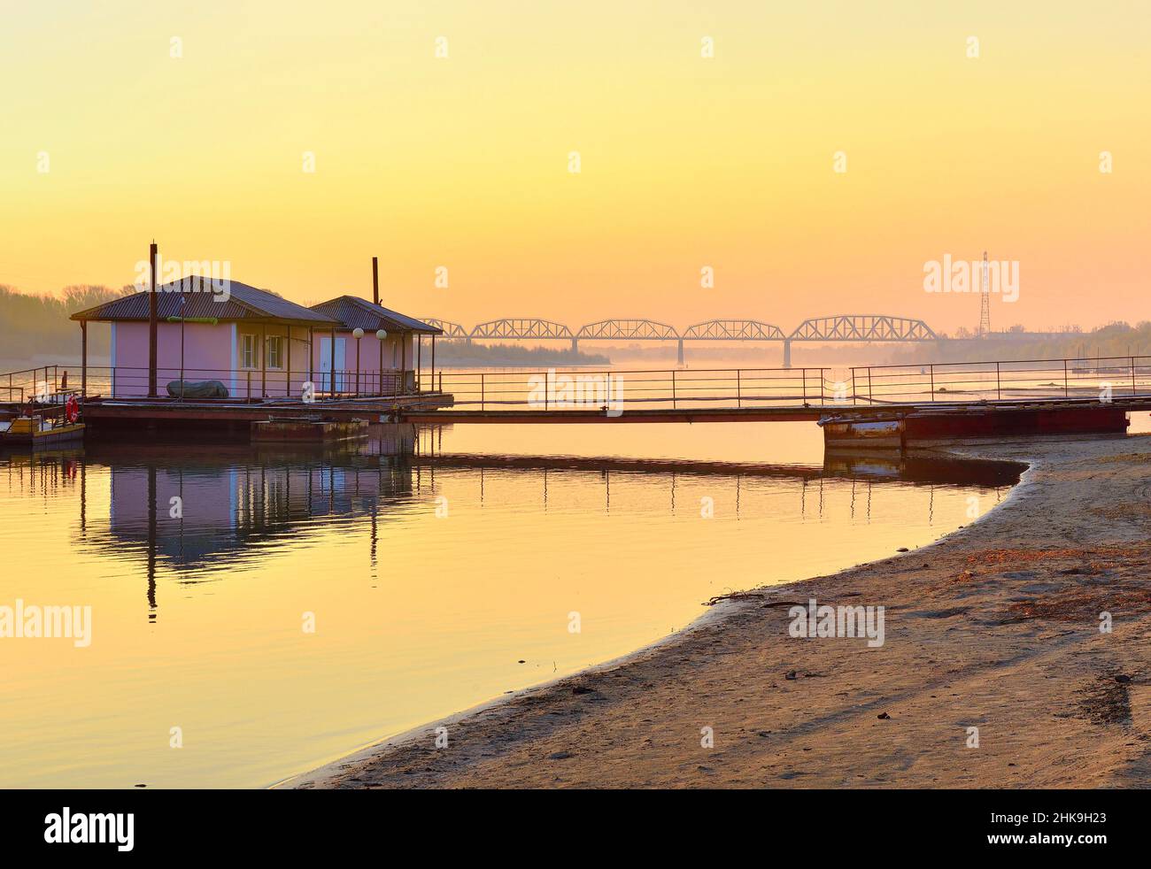 The bank of the Ob River. Sandy beach, boat pier, railway bridge on the ...