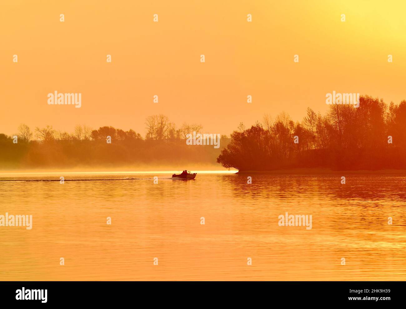 The bank of the Ob River. A boat in the morning fog on the golden ...