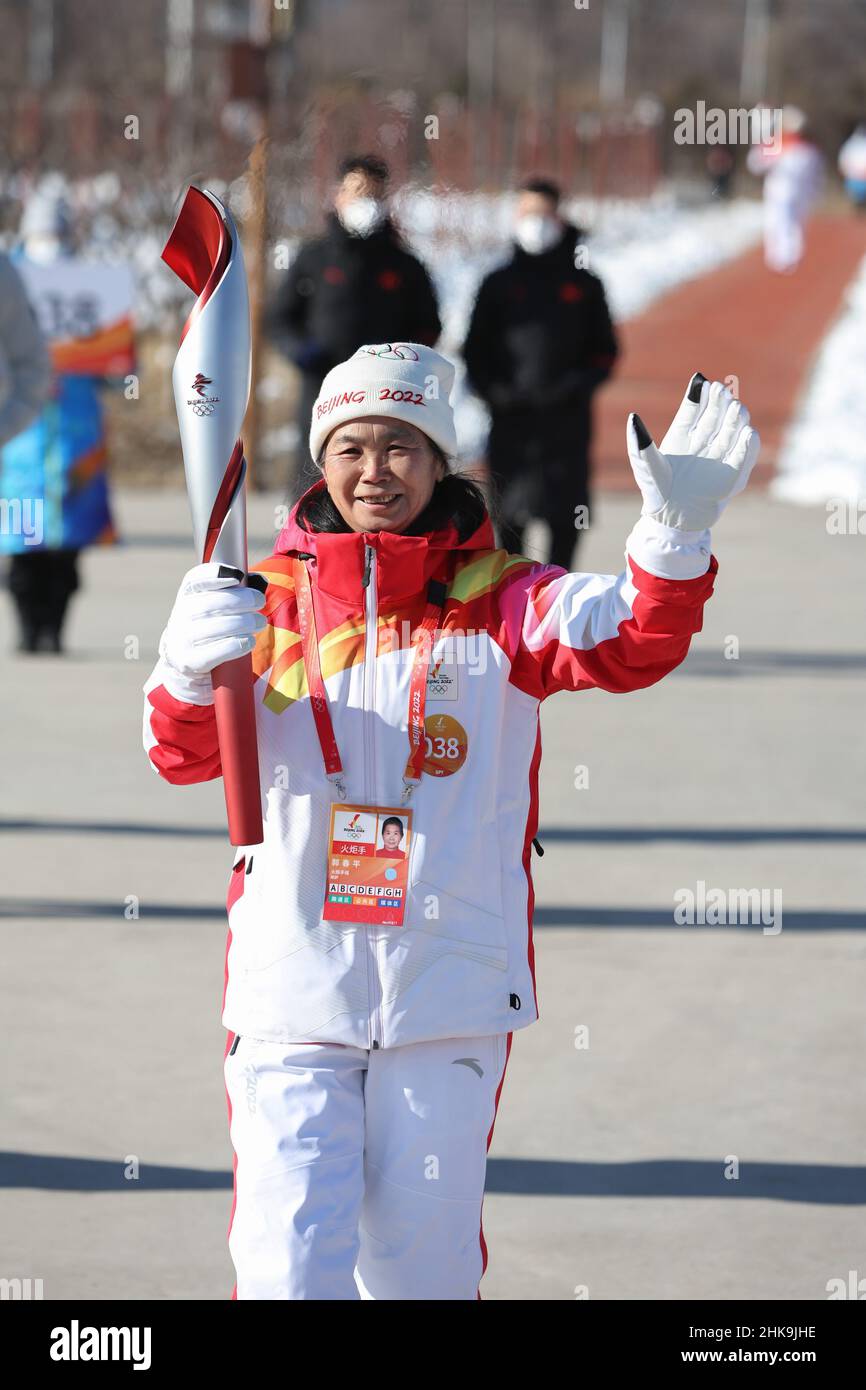 Beijing, China. 3rd Feb, 2022. Torch bearer Guo Chunping runs with the torch during the Beijing ...