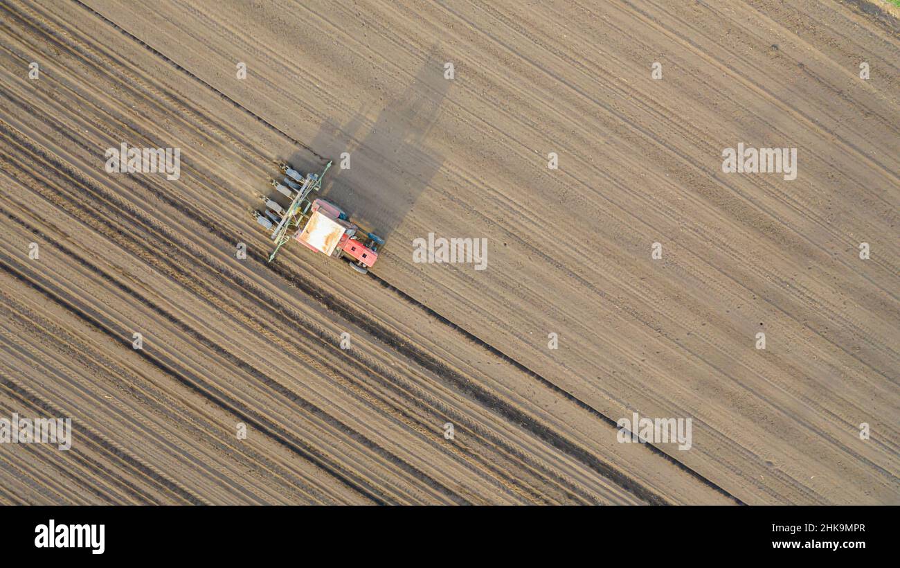Above top view, of tractor as pulling mechanical seeder machine over ...