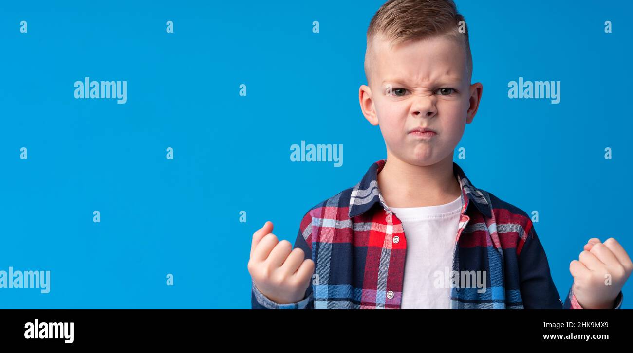 Portrait of angry little boy on blue background Stock Photo - Alamy