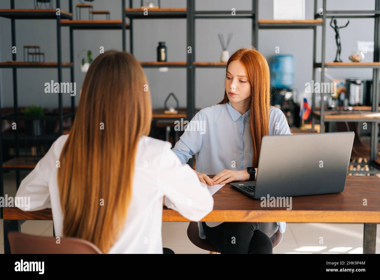 View from back to female applicant during job interview talking with ...