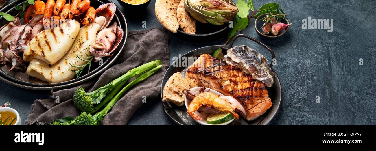 Grilled fish and seafood assortment on dark background. Homemade food ...