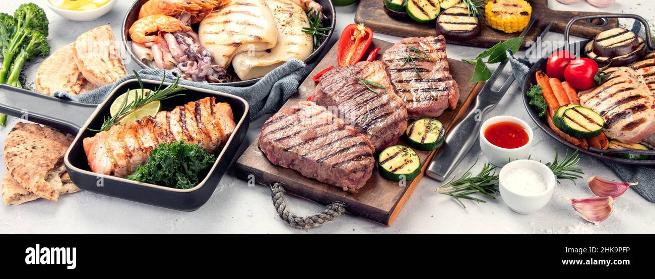 Grilled fish, seafood and meat assortment on light background. Homemade ...