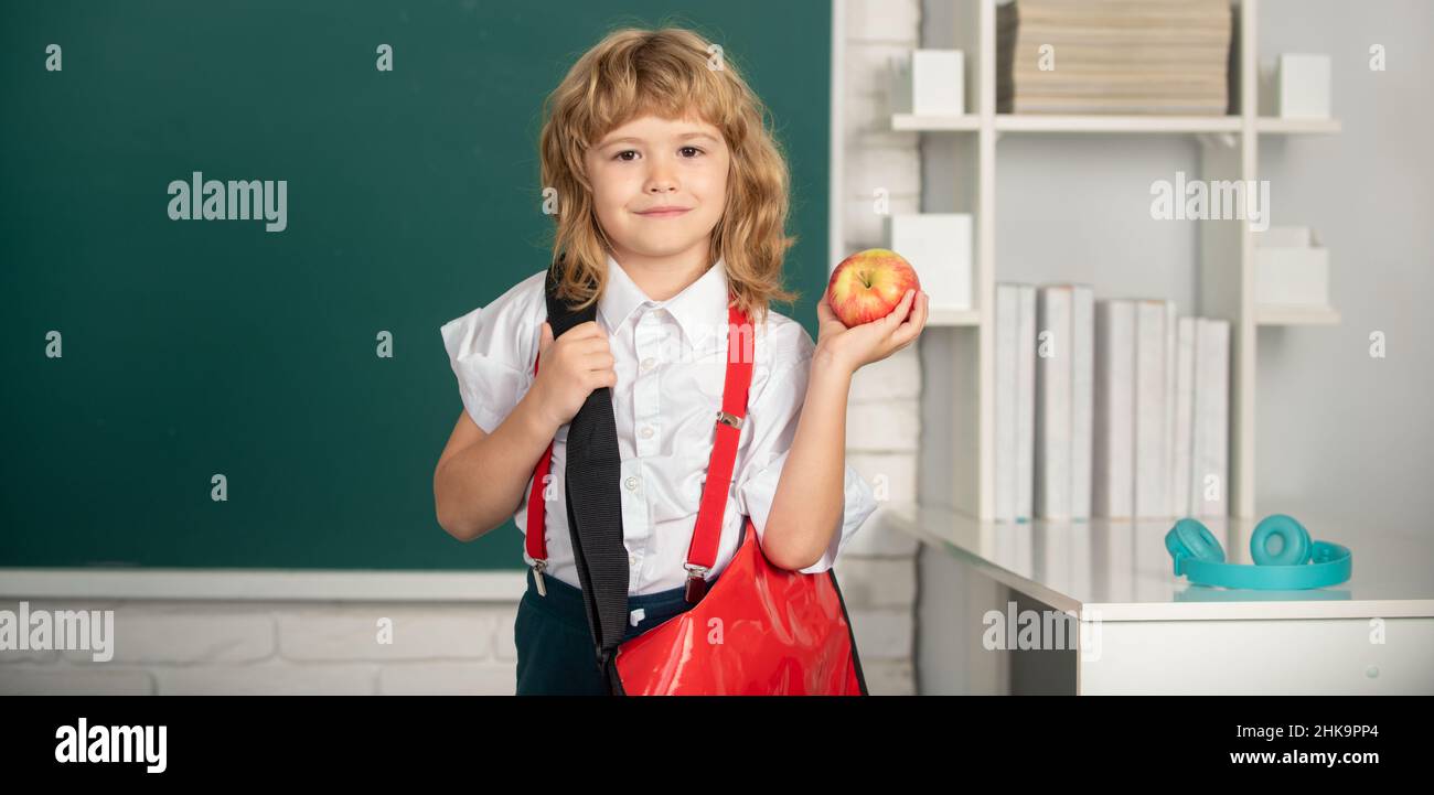 Kid boy with backpack and apple at school. Elementary school child in ...