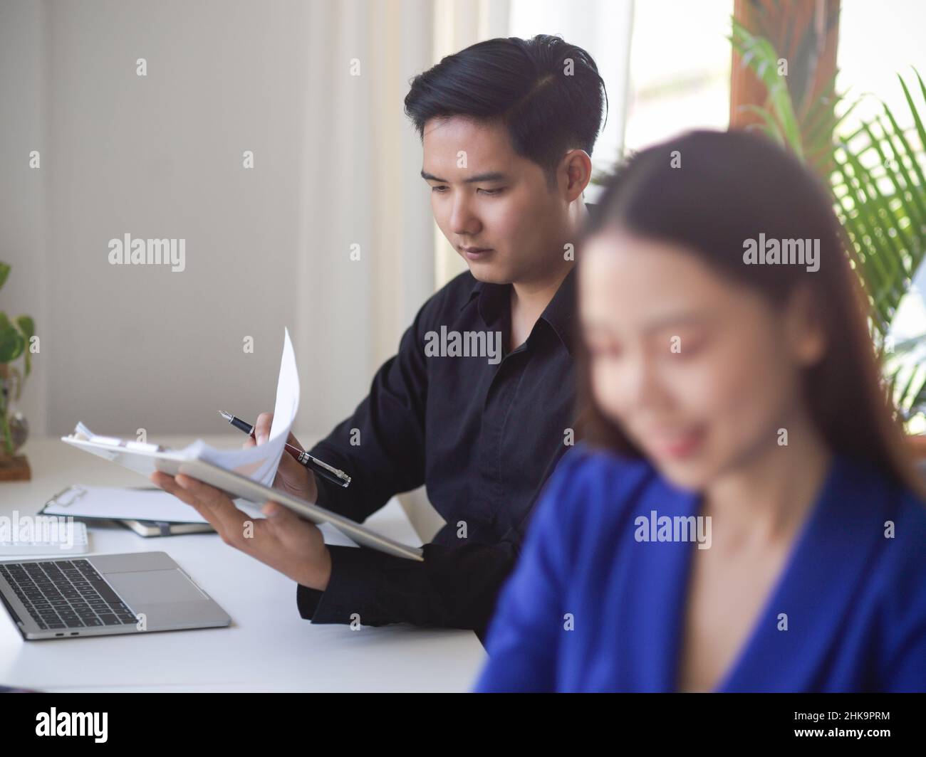 Financial male boss checking the financial details on the report at his ...