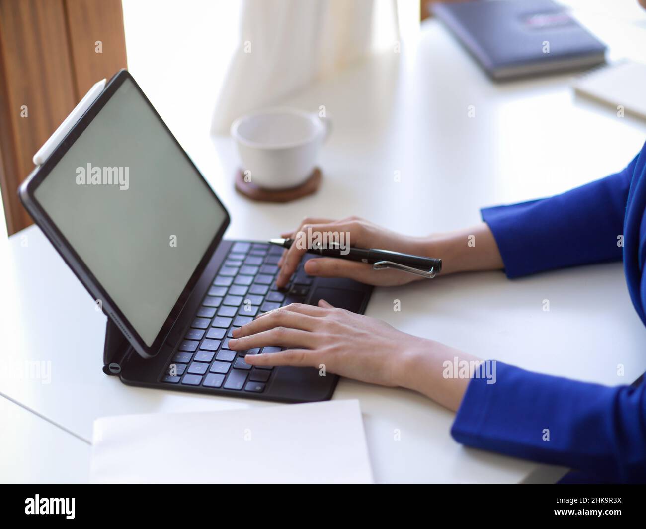 Side view, A businesswoman typing on portable tablet touchpad keyboard ...