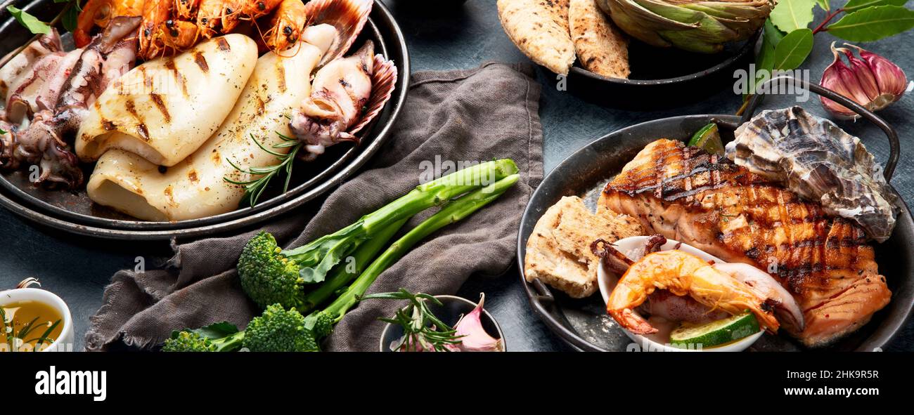 Grilled fish and seafood assortment on dark background. Homemade food ...