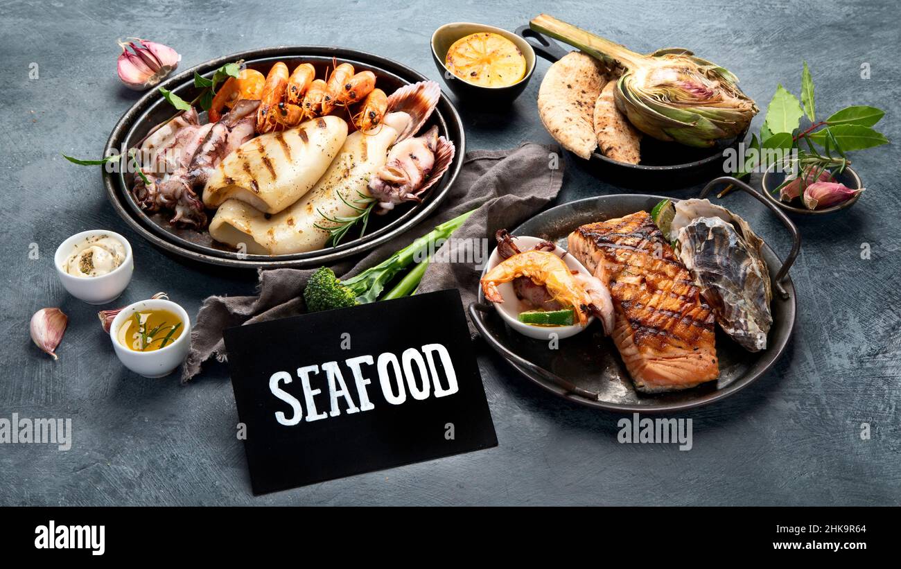 Grilled fish and seafood assortment on dark background. Homemade food ...