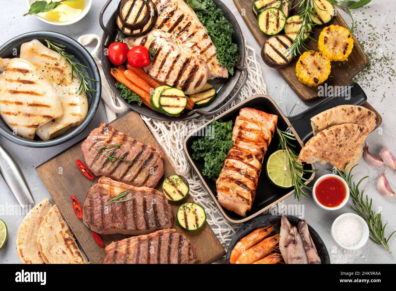 Grilled fish, seafood and meat assortment on light background. Homemade ...