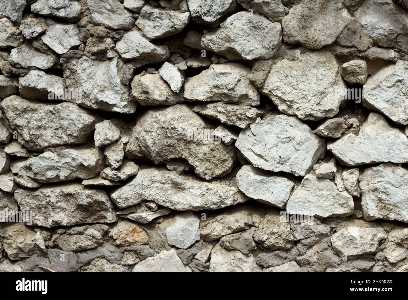 Old dilapidated wall of gray stone booth, cement sprinkled in places ...