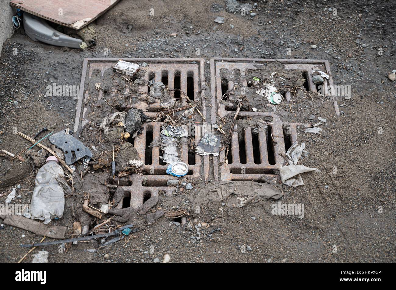 Sewer manhole covered with trash and mud Stock Photo - Alamy