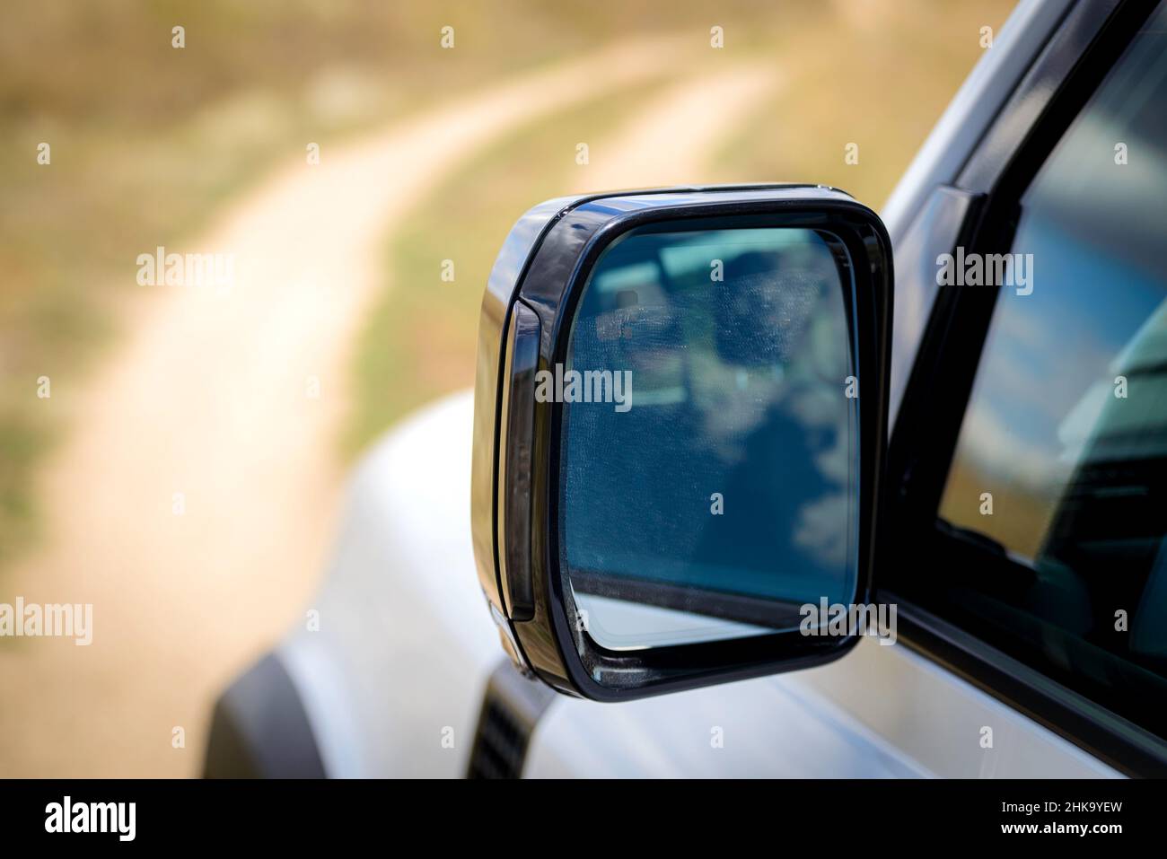 Close-up of the side left mirror and window of the car body white SUV ...