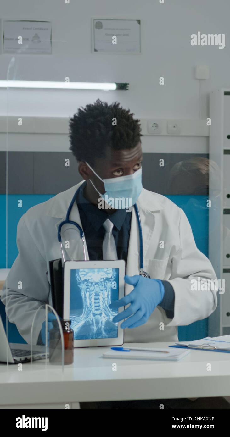 Black doctor holding digital tablet with x ray scan explaining checkup ...