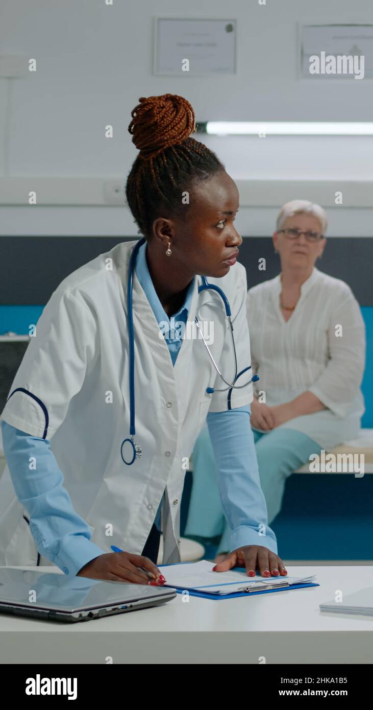 Medic and nurse talking about examination results while using patient ...