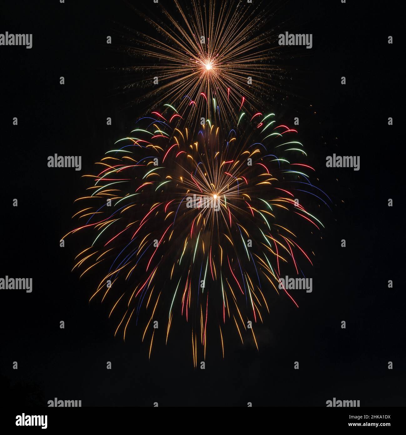 Beautiful fiery rays of light from explosion of pyrotechnics on black ...