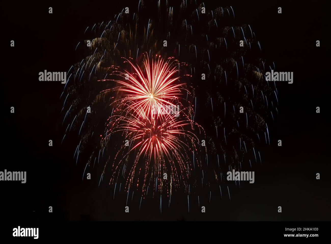 Beautiful fiery rays of light from explosion of pyrotechnics on black ...