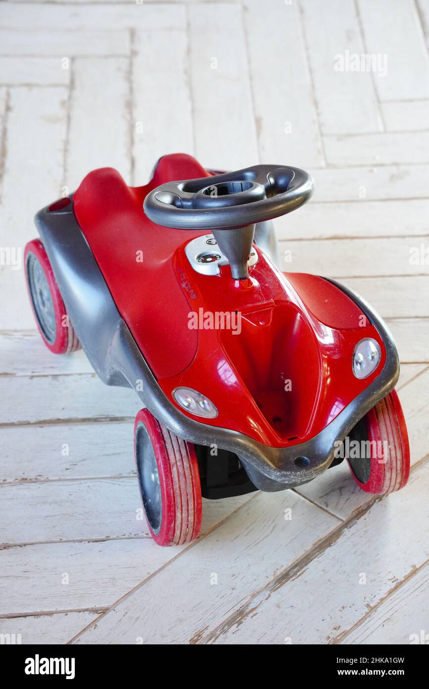 Small red toy car on the floor Stock Photo - Alamy