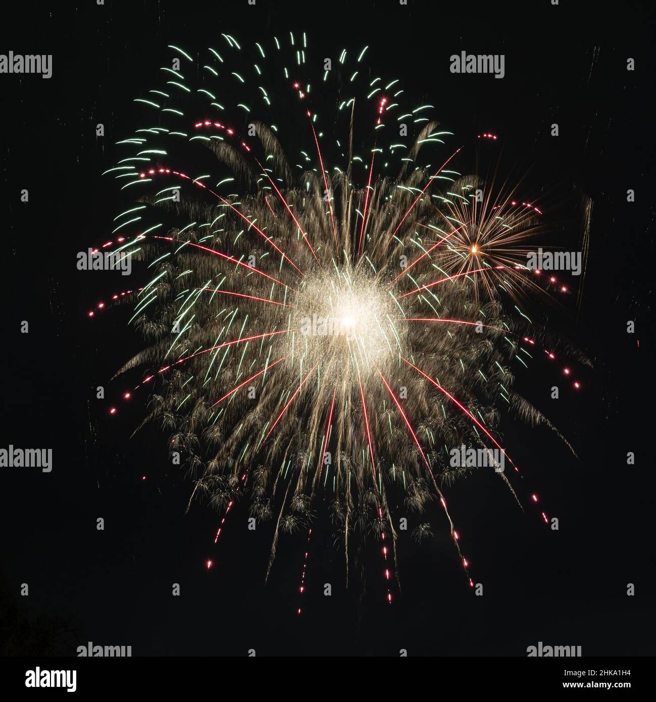 Beautiful fiery rays of light from explosion of pyrotechnics on black ...