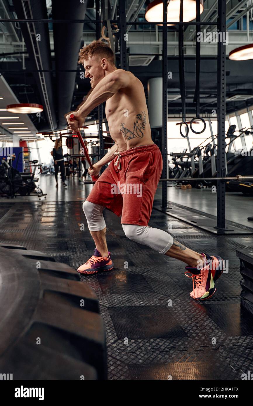 Strength concept. Male athlete using hammer during fitness workout ...