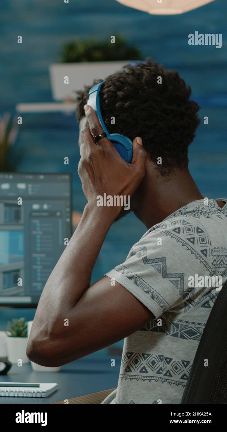 Engineer wearing headphones and designing building model for ...