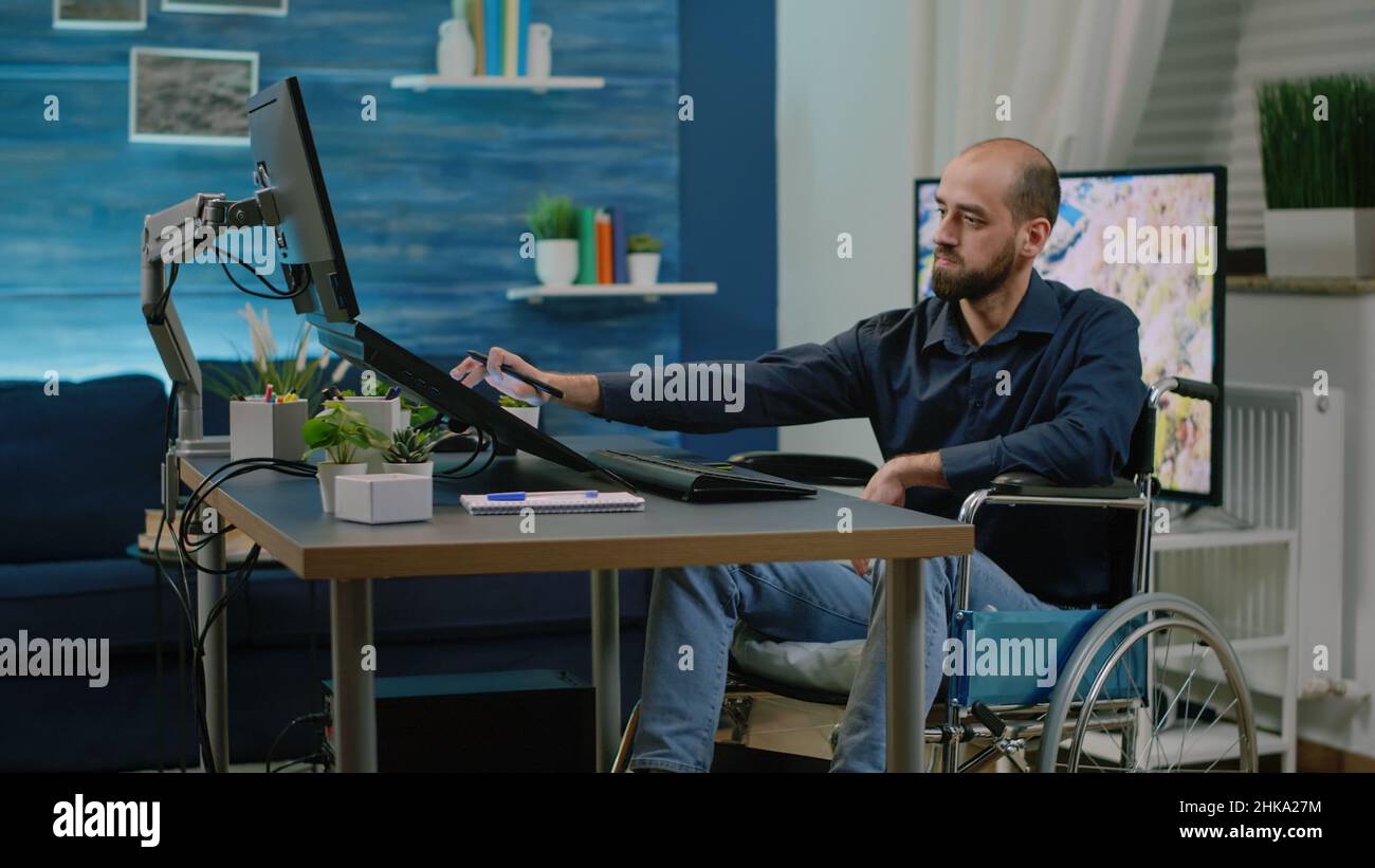 Disabled photographer editing pictures in photography studio. Man with ...