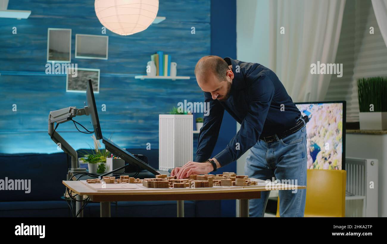Man Working As Architect Analyzing Building Model And Layout For Construction Project Engineer