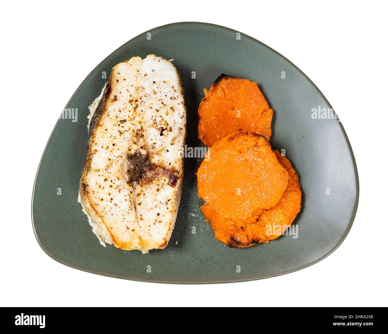 top view of baked cod steak with boiled sweet potato slices on green ...
