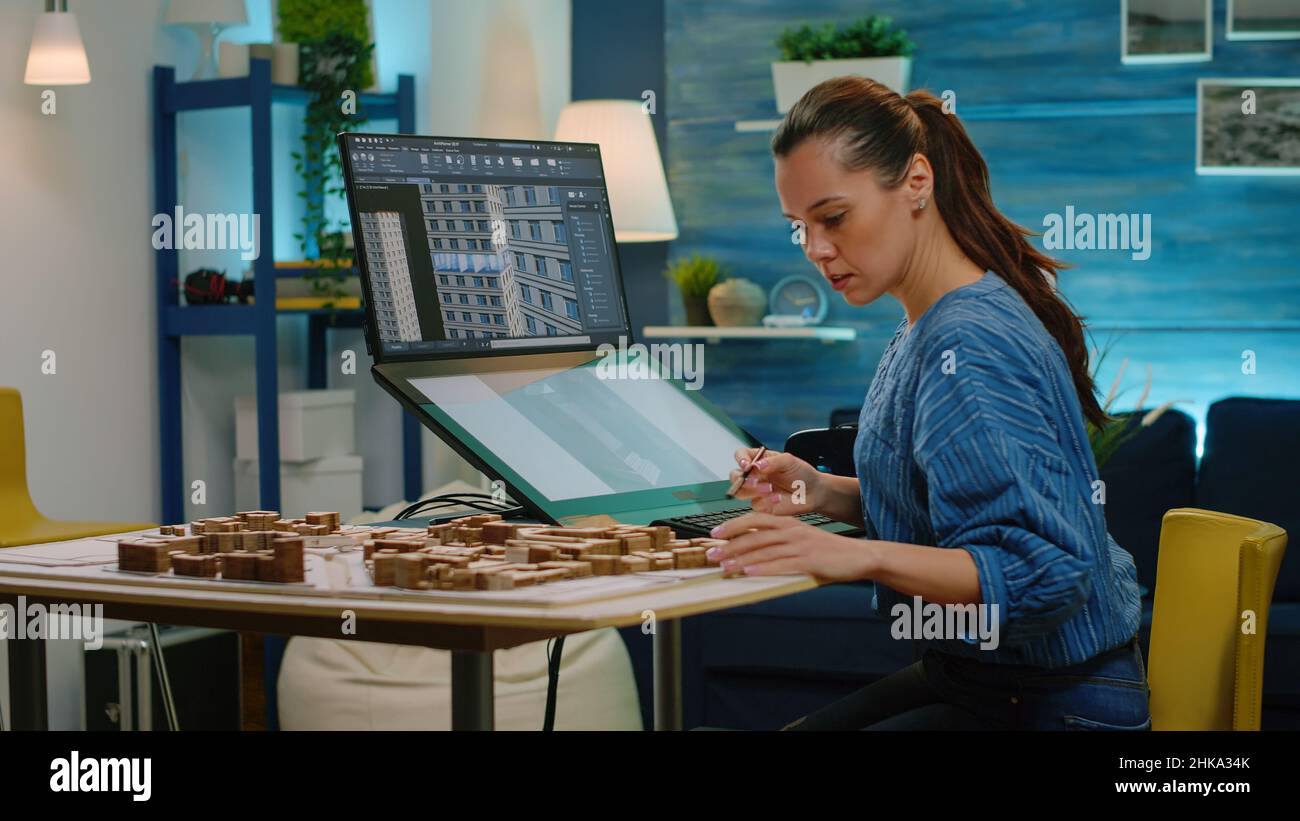 Engineer analyzing building model and maquette using touch screen ...